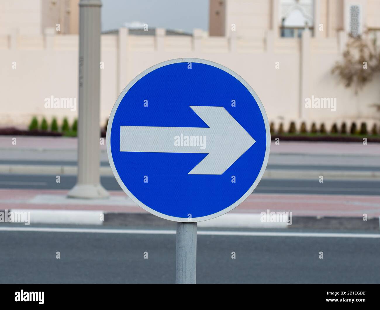White arrow on blue traffic sign on the road Stock Photo - Alamy