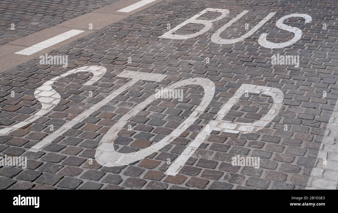 Bus stop sign painted in white color on the tiles on the road Stock ...