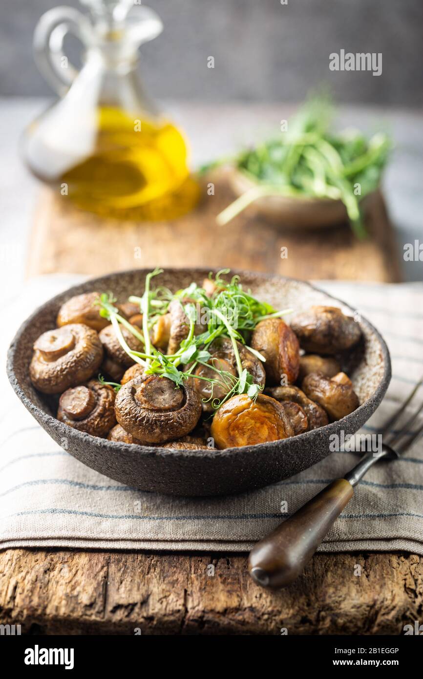 Baked champignons mushrooms with butter and roasted garlic in a bowl ...