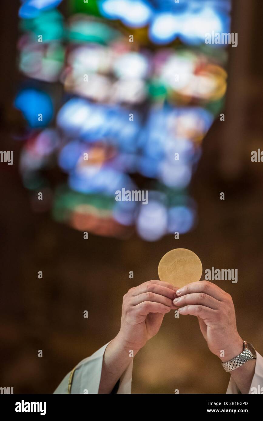 Minister showing the holy bread during the rite of the Holy Communion ...