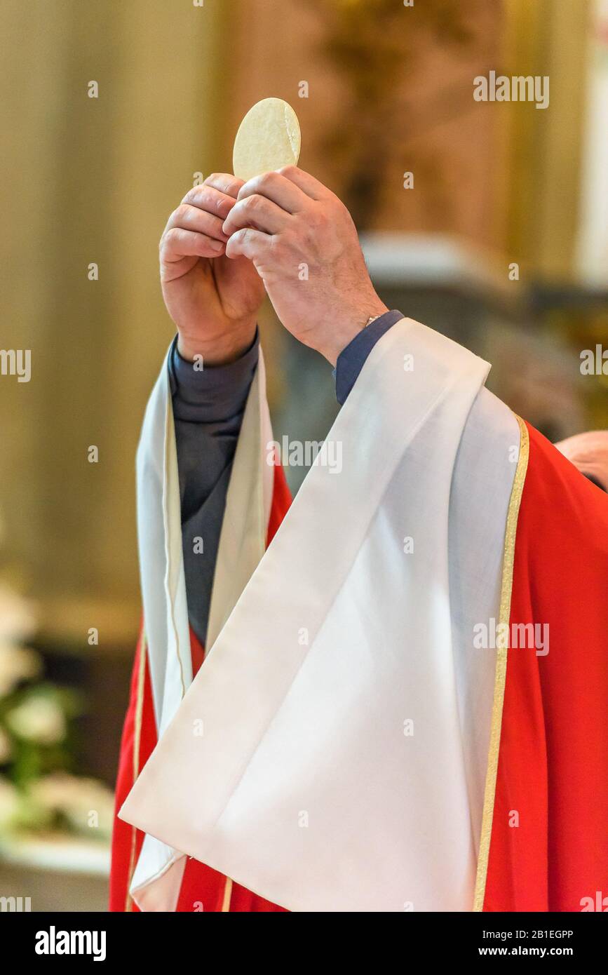 Minister showing the holy bread during the rite of the Holy Communion ...