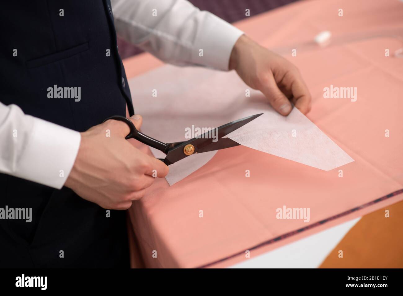 Hands of male tailor cutting out paper pattern Stock Photo - Alamy