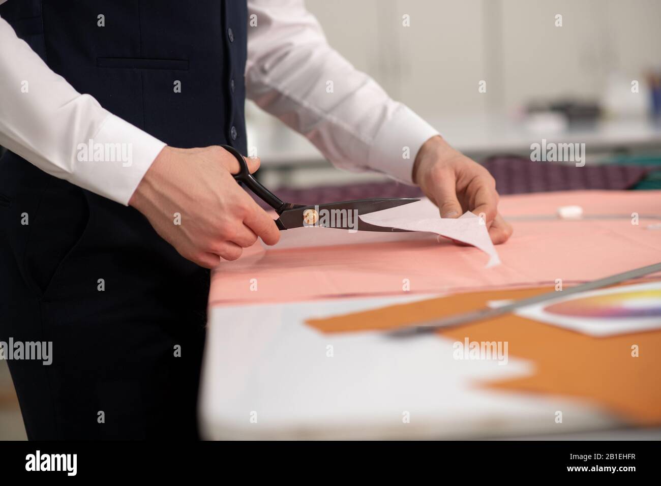 Hands of male tailor cutting out paper pattern Stock Photo - Alamy