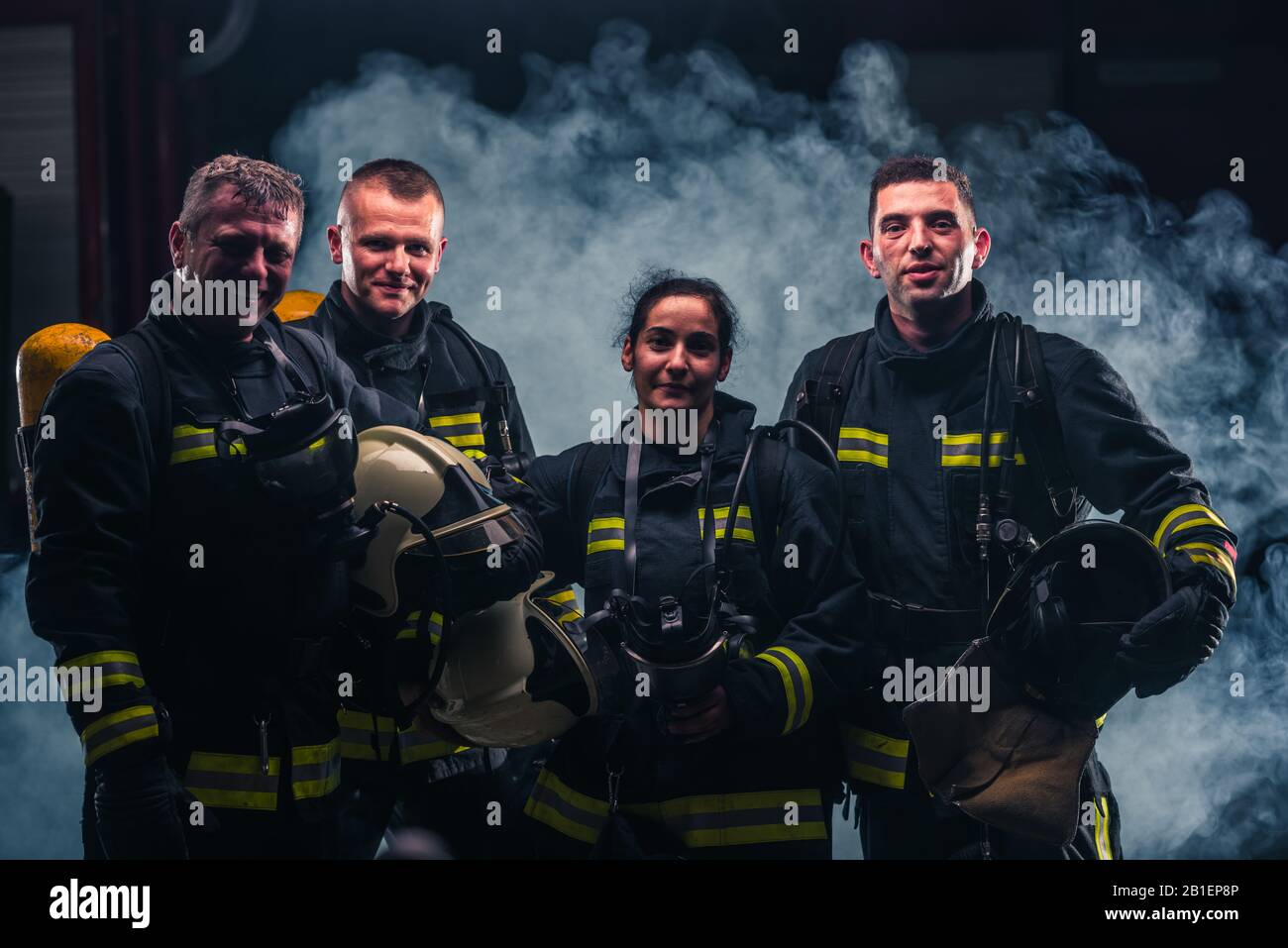 Group picture of firefighters with fire extinguisher's smoke in the ...