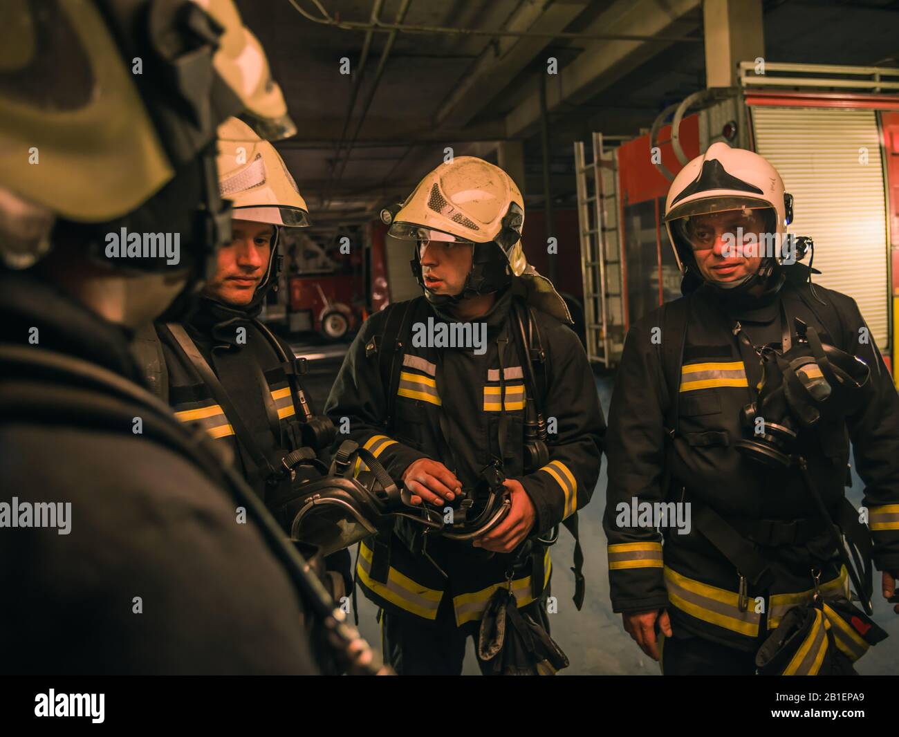 Group of firefighters with uniform inside the fire station preparing ...