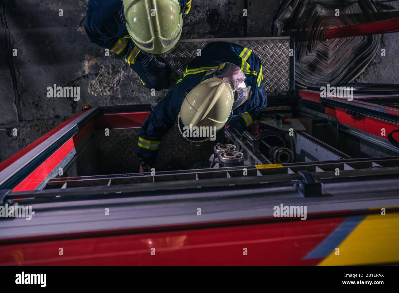 Firemen checking the fire engine inside the fire department from a bird ...
