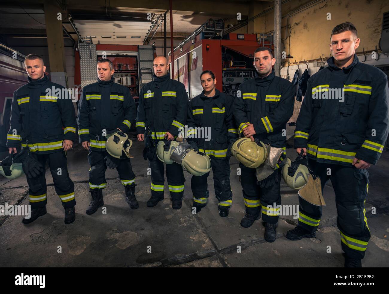 Portrait of firefighters standing by a fire engine Stock Photo - Alamy