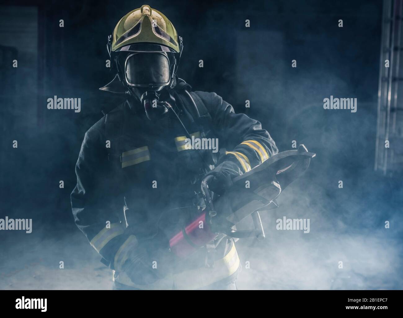 Portrait of a fireman wearing firefighter turnouts and helmet. Dark ...