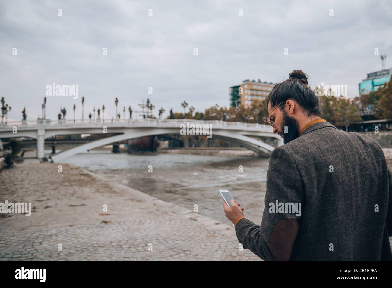 Stylish hipster with a long beard during a business phone conversation ...