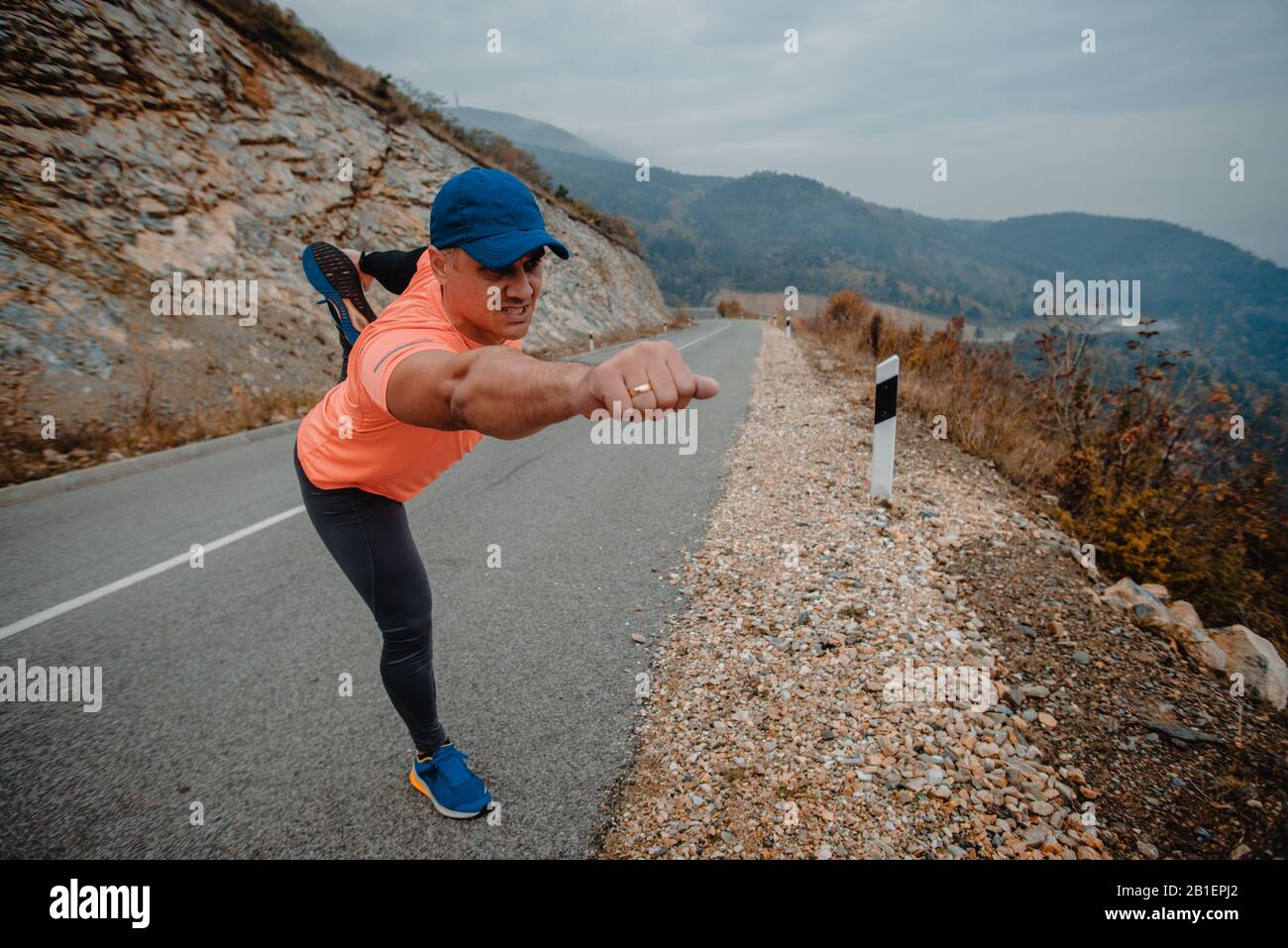 Well built mature runner dressed in fitness wear preparing for a run ...
