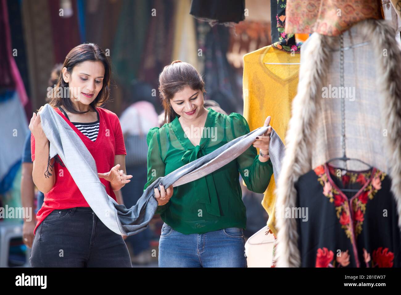 Two women shopping for dress at street market Stock Photo - Alamy