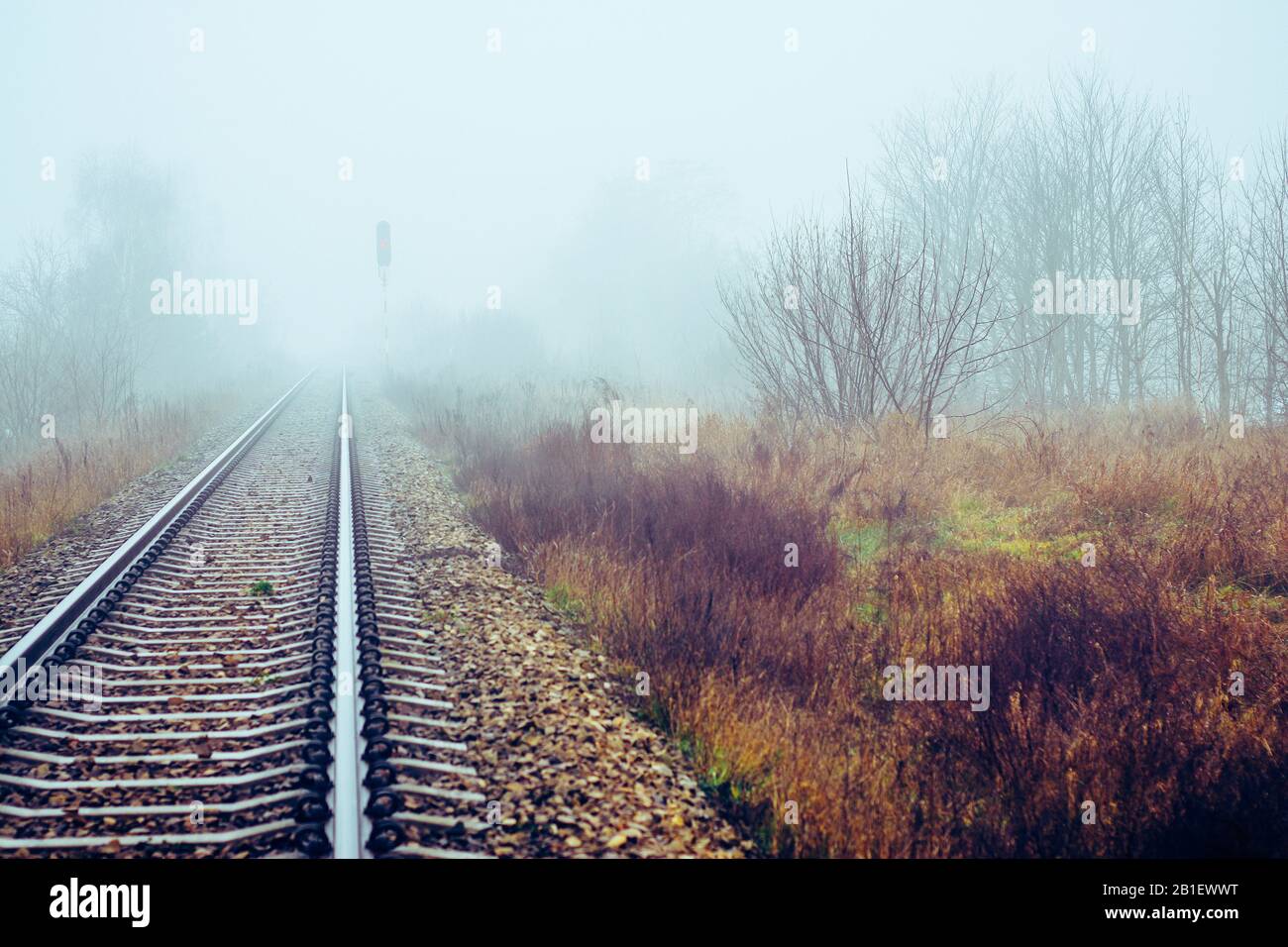 Perspective of railway track disappearing in mist in foggy morning ...