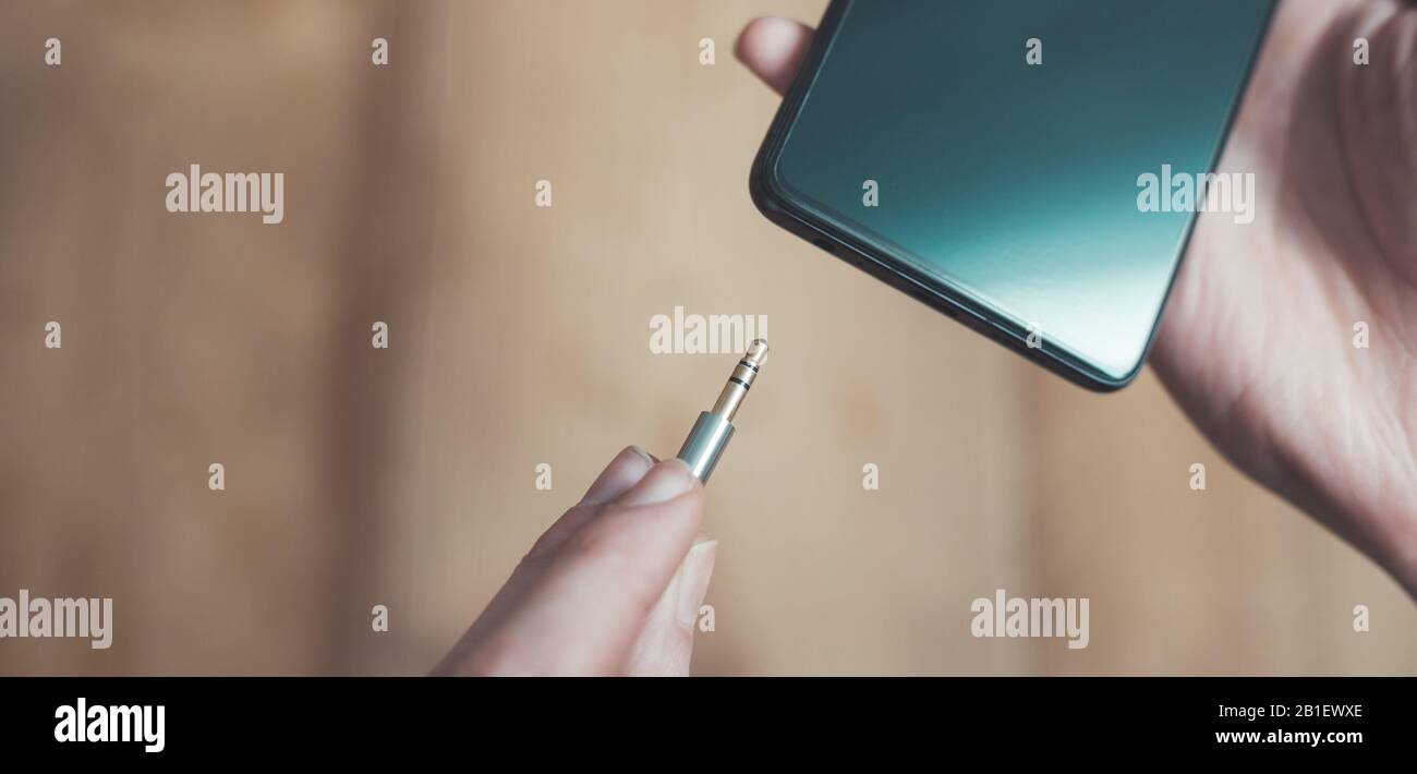 Connection 3.5mm audio jack to a black mobile phone Stock Photo - Alamy