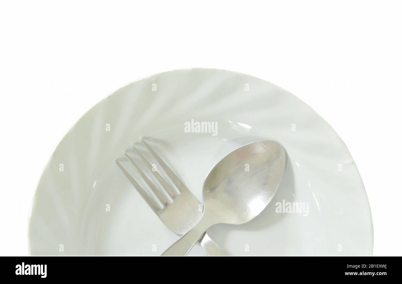 spoon and fork crossing on dish in white background Stock Photo - Alamy