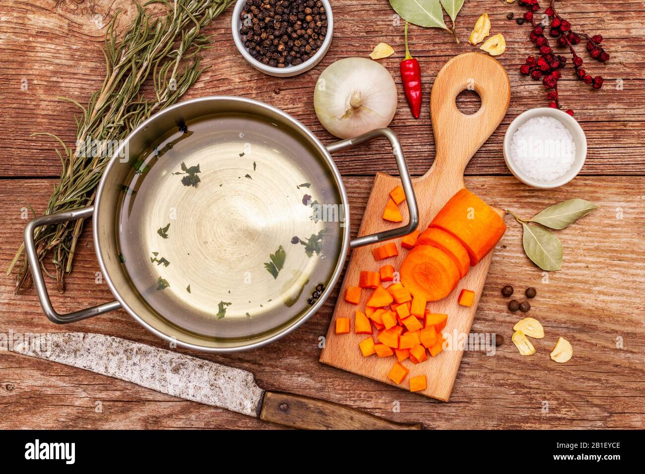 Transparent duck broth in pan with fresh ingredients. Traditional ...