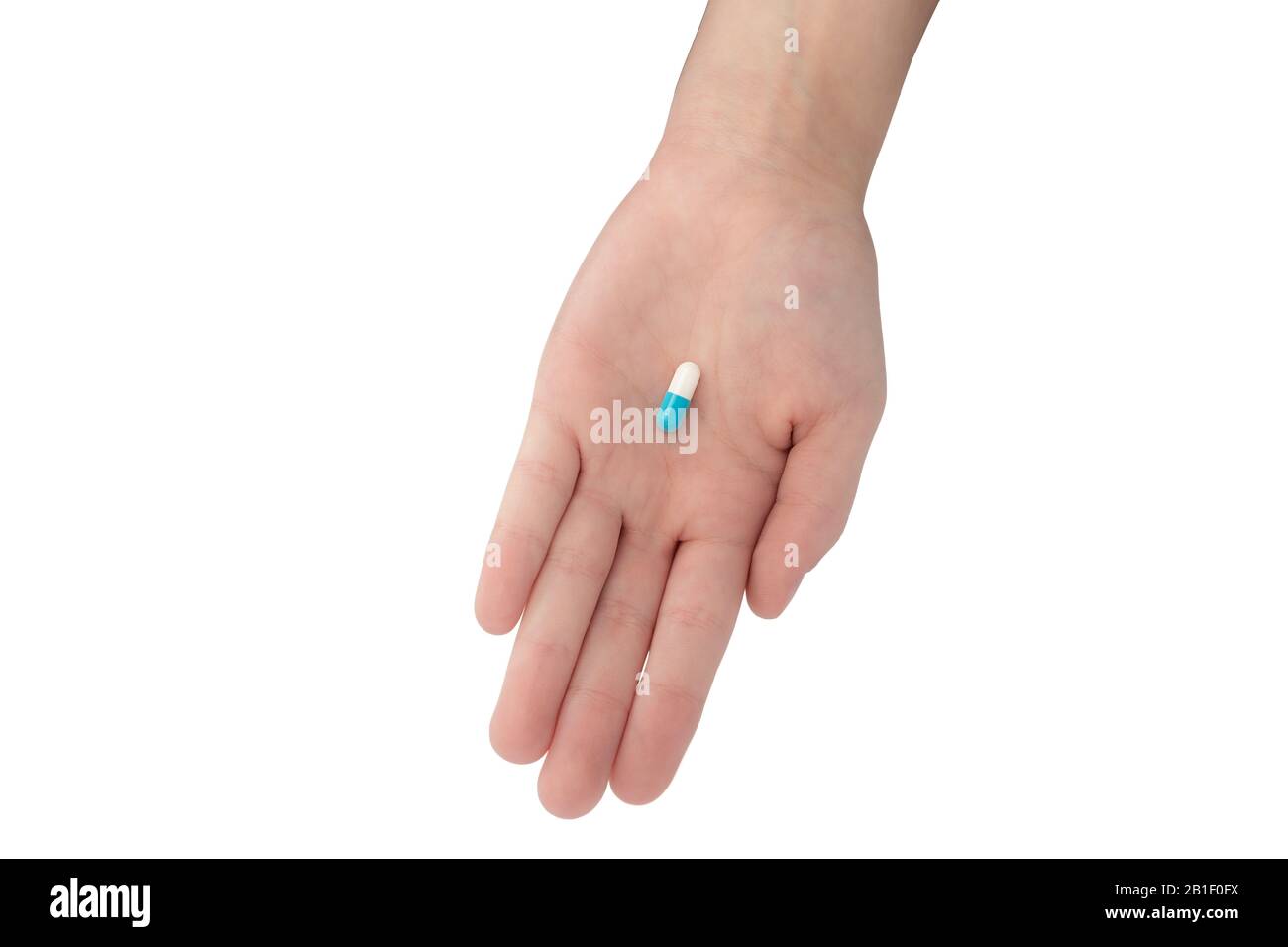 Young woman's hand offering blue and white capsule isolated on white ...