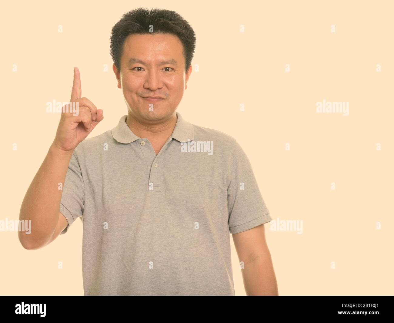 Studio shot of Japanese man pointing finger up Stock Photo - Alamy