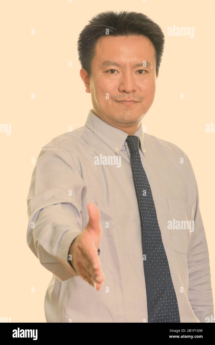Studio shot of Japanese businessman giving handshake Stock Photo - Alamy