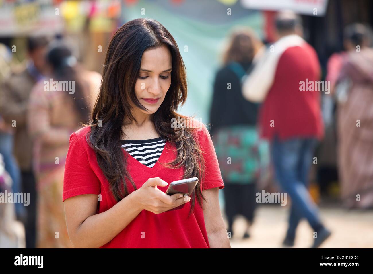 Happy woman texting on mobile phone at market Stock Photo - Alamy