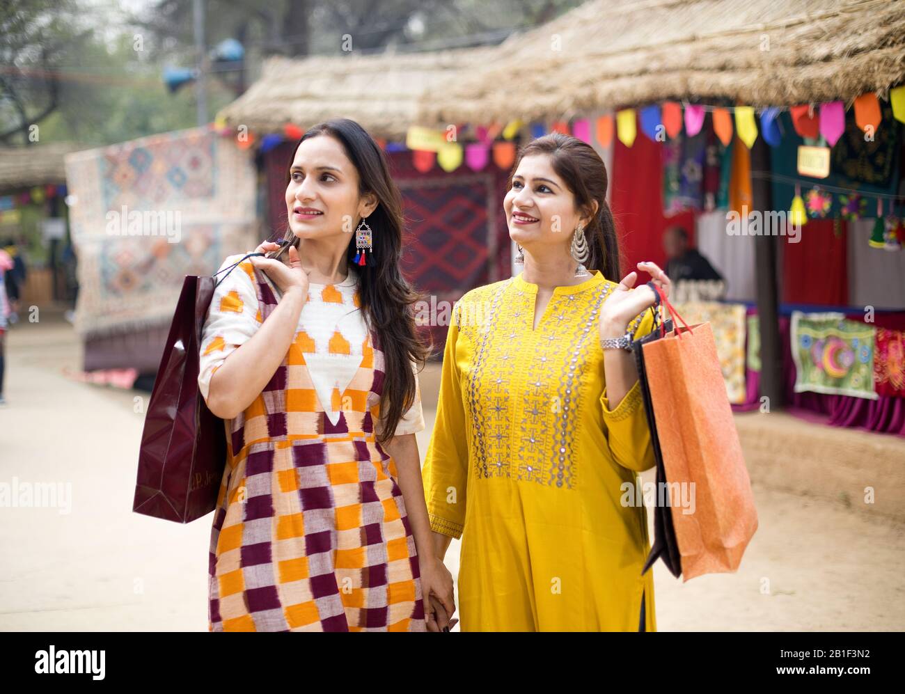 Two happy Indian women shopping at street market Stock Photo - Alamy