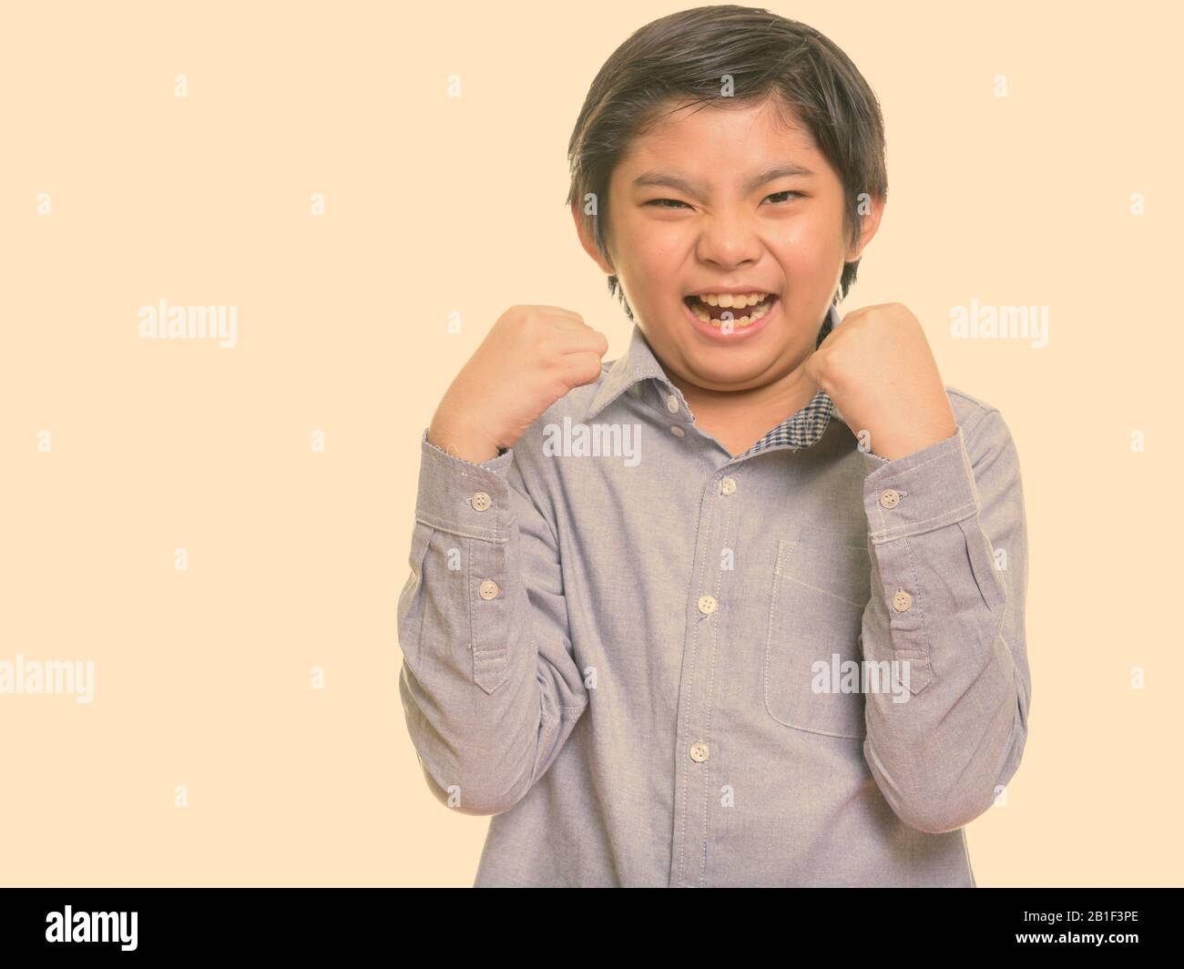 Studio shot of happy cute Japanese boy smiling and looking excited ...