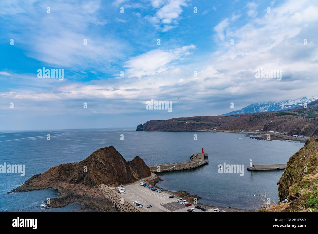 View of Utoro fishing port in springtime with Shiretoko mountain range ...