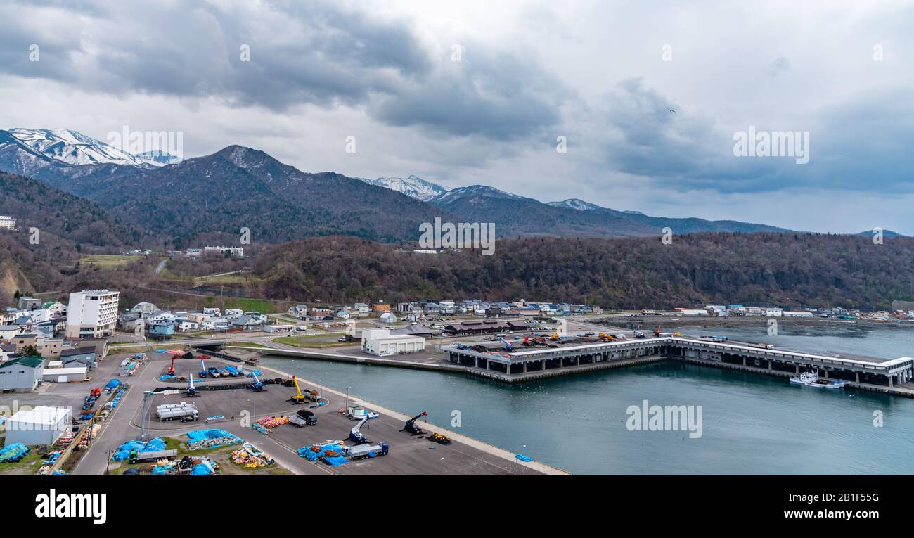 View of Utoro fishing port in springtime with Shiretoko mountain range ...