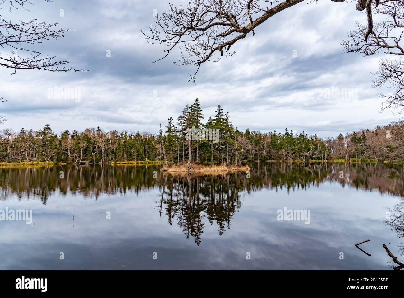 Small islet in the lake, beautiful lake surface reflecting blue sky ...
