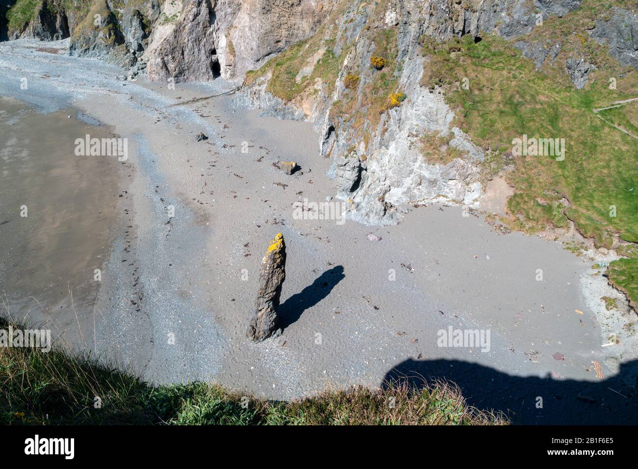 A secluded small beach with picturesque stone pillar and cliffs Stock ...