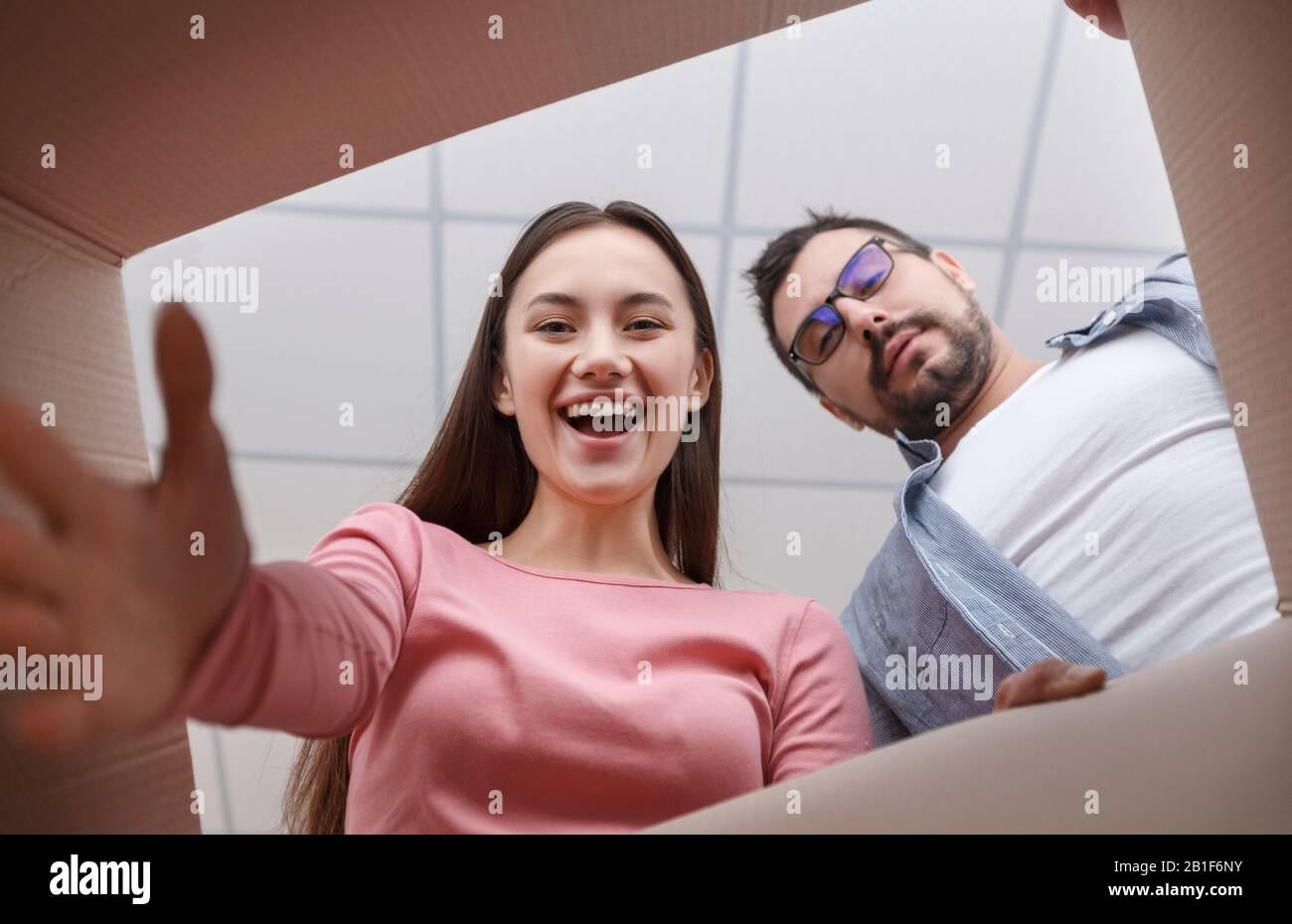 Woman and man are looking into box Stock Photo - Alamy