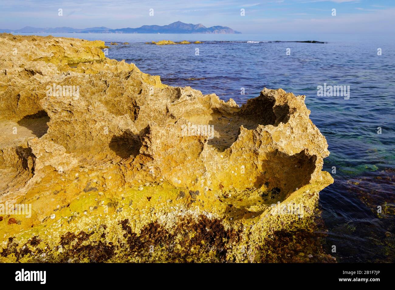 Sharp-edged eroded limestone cliffs on the coast near Can Picafort ...