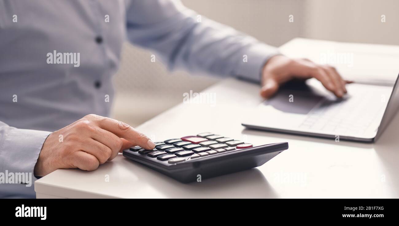 Senior man using laptop and calculator at home Stock Photo - Alamy