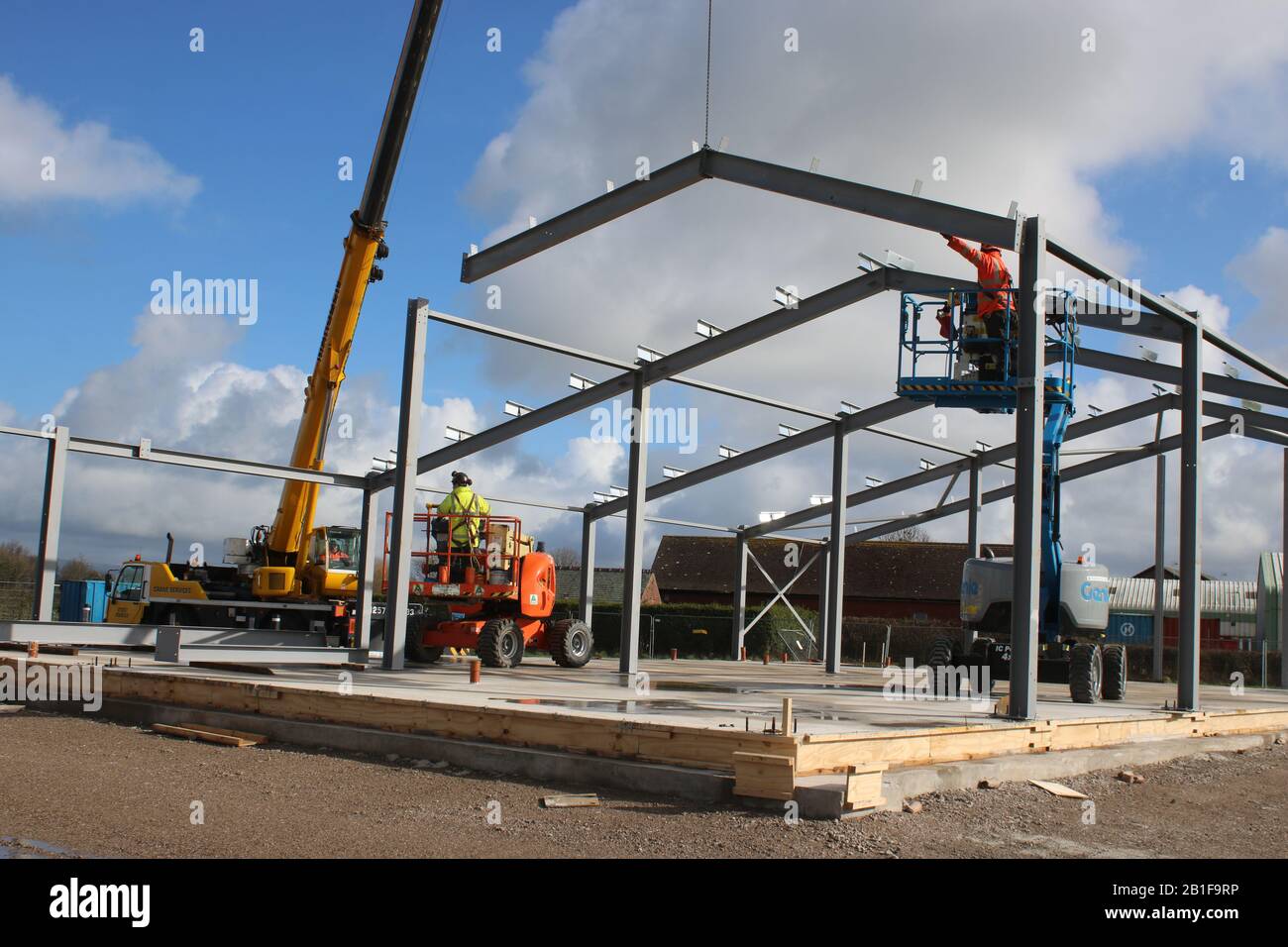 Men on self propelled articulated platforms constructing steel ...