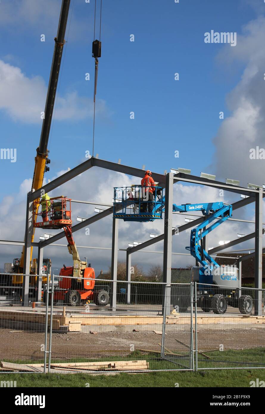Men on self propelled articulated platforms constructing steel ...