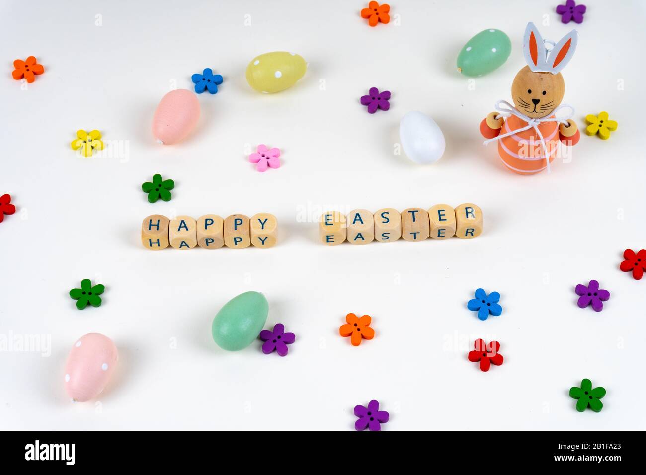 Wooden blocks with letters saying "Happy Easter" in front of colorful ...