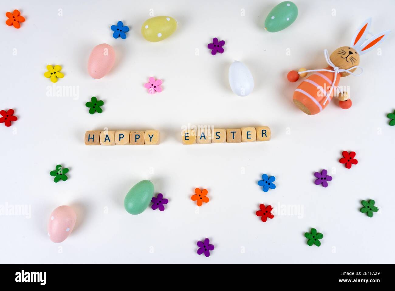 Wooden blocks with letters saying "Happy Easter" in front of colorful ...