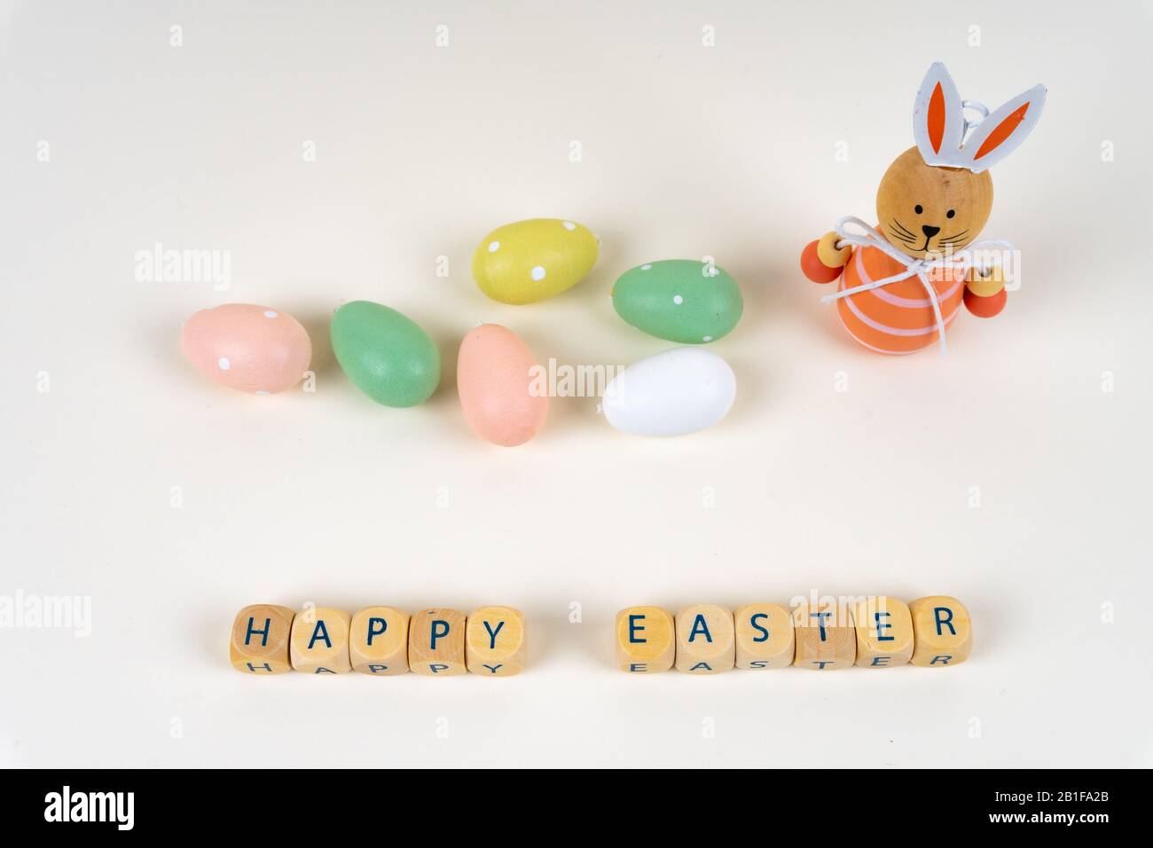 Wooden blocks with letters saying "Happy Easter" in front of colorful ...