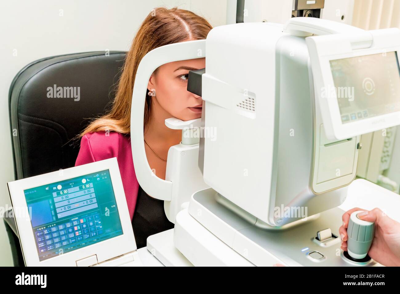 Beautiful woman having an eye lens exam with auto refractor keratometer ...