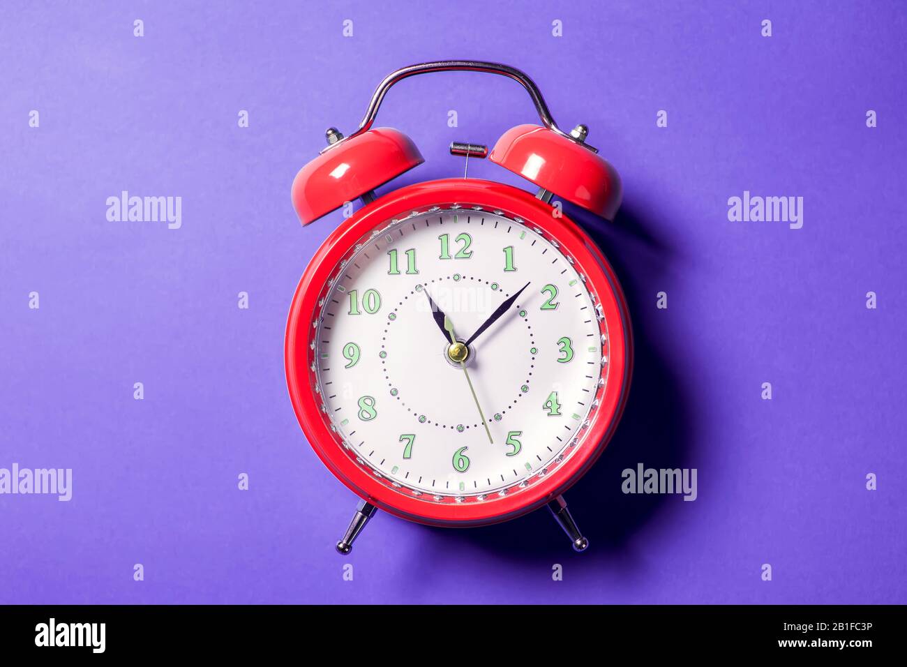 Red alarm clock on the color background Stock Photo - Alamy