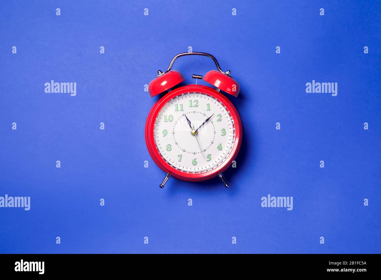 Red alarm clock on the color background Stock Photo - Alamy