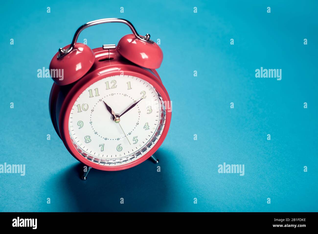 Red alarm clock on the color background Stock Photo - Alamy