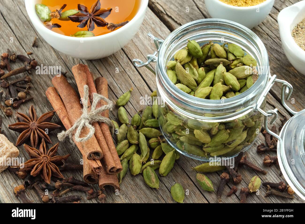 Jar of aromatic cardamom pods and cup of healthy ayurvedic masala tea ...