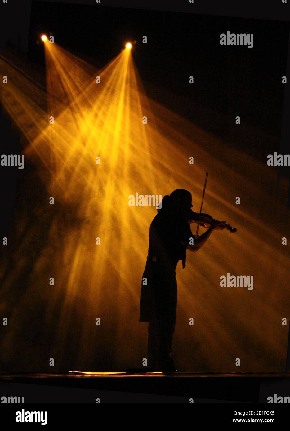 Violin player in the spot light of the stage. Performing violinist on a ...