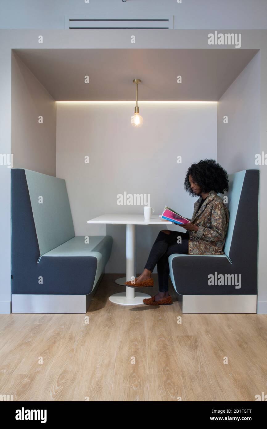 young woman reading in seating booth Stock Photo - Alamy