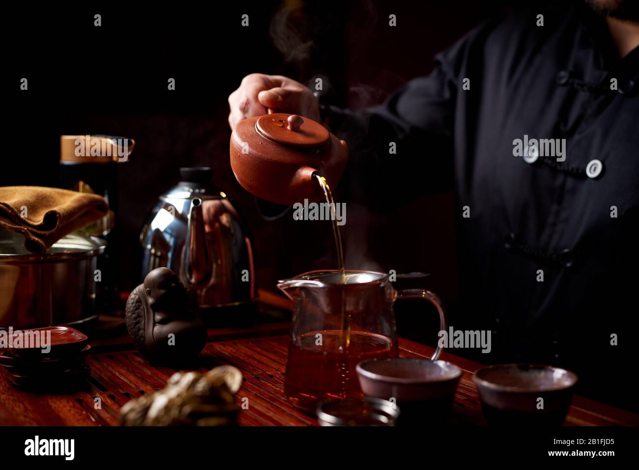 Tea ceremony. A young man pours tea from a teapot Stock Photo - Alamy