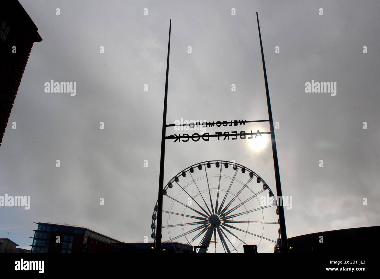 sign for liverpool albert docks and ferris wheel in silhouette england ...