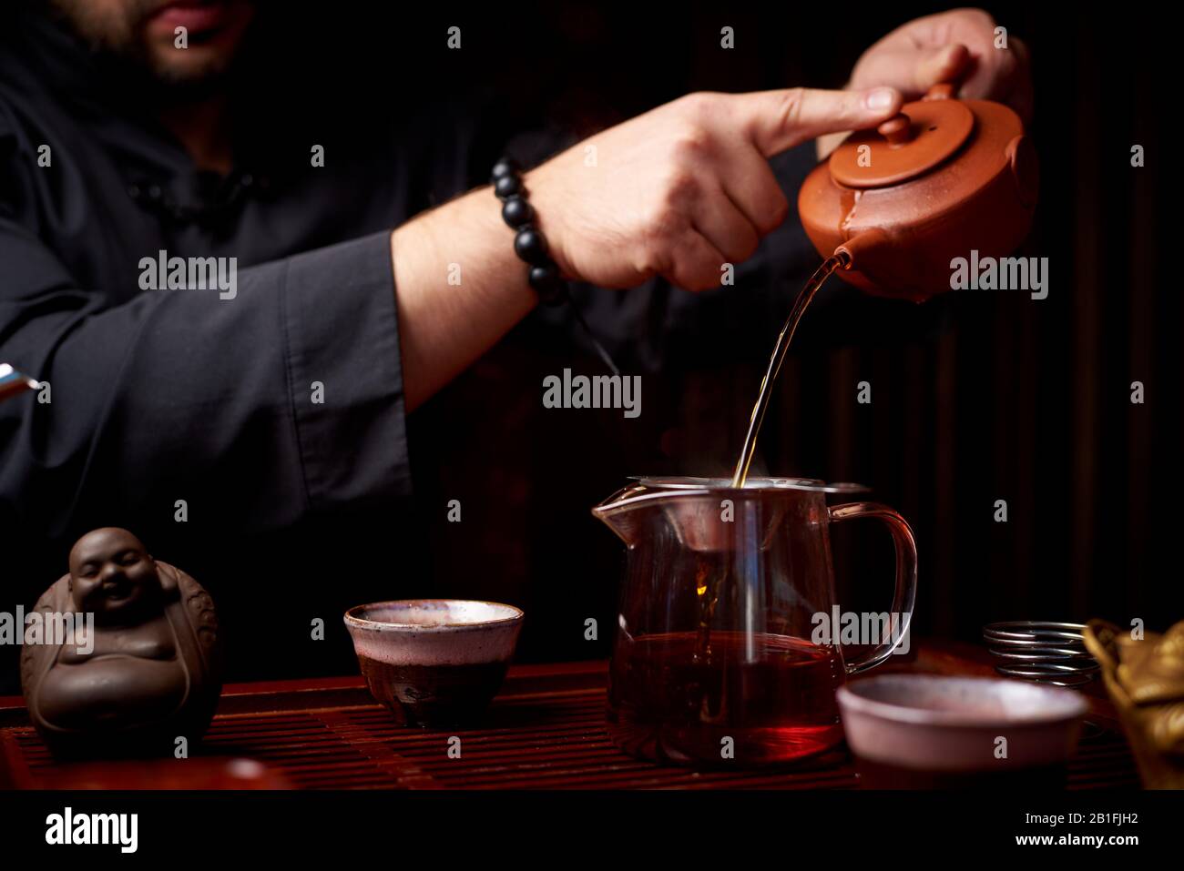 Tea ceremony. A young man pours tea from a teapot Stock Photo - Alamy