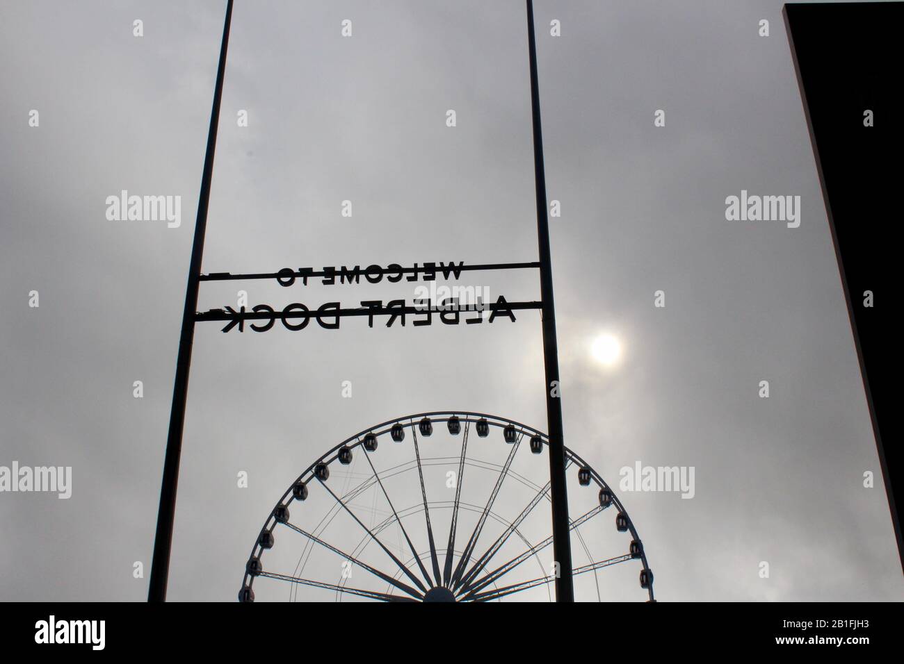 sign for liverpool albert docks and ferris wheel in silhouette england ...