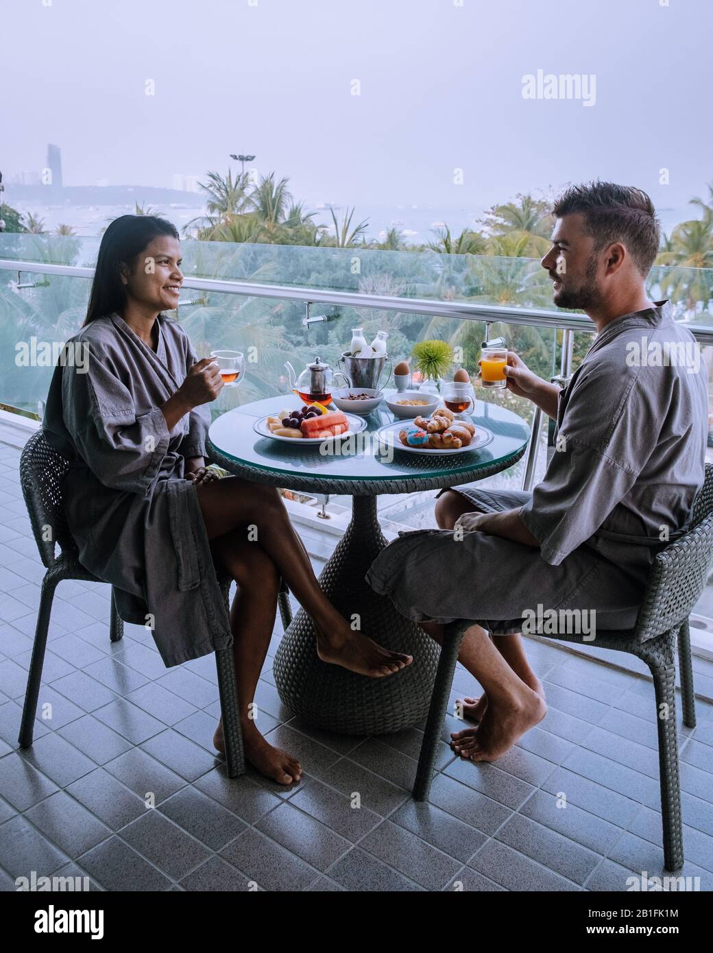 Breakfast on Balcony with a look over Pattaya Thailand, couple having ...