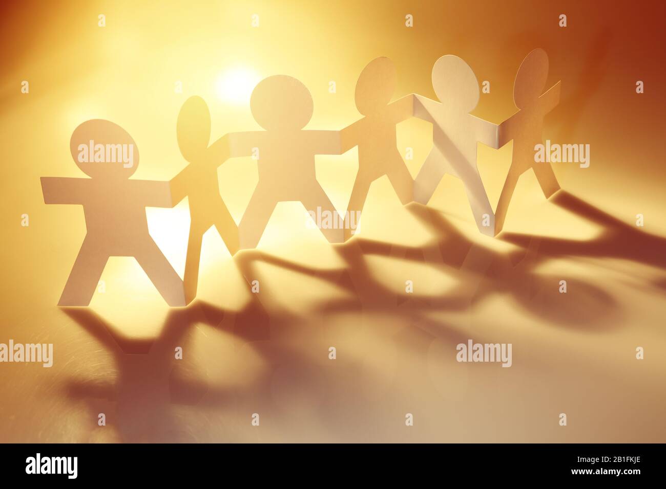 Paper chain team holding hands. Teamwork. Partnership Stock Photo - Alamy